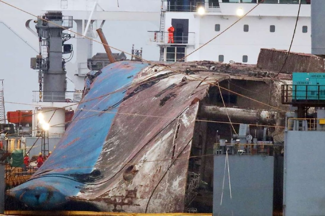 Raised Sewol ferry loaded onto transport vessel, completing most ...